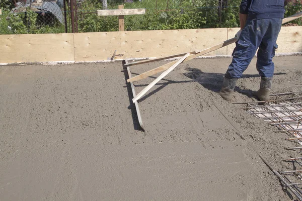 Worker leveling fresh concrete slab with a special working tool Stock ...