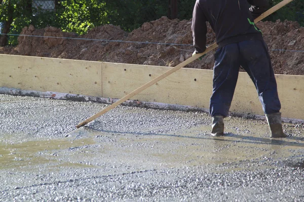 Worker leveling fresh concrete slab with a special working tool Stock ...