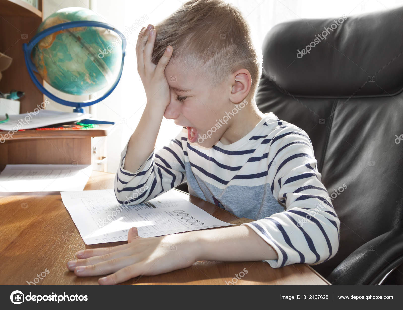 School-age boy crying and screaming while doing homework. the co Stock ...