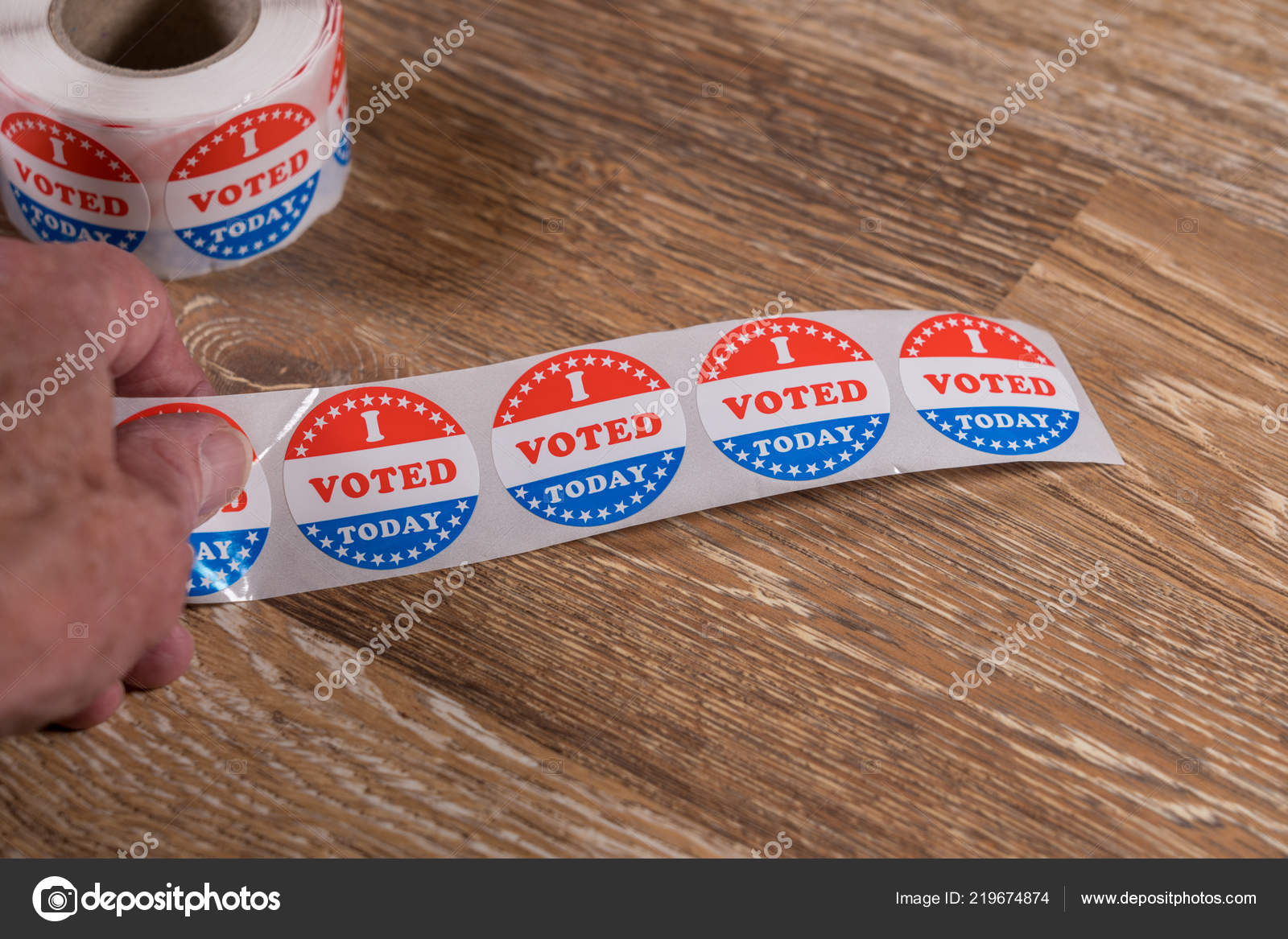 Roll of I Voted Today paper stickers on table with senior man hand ...