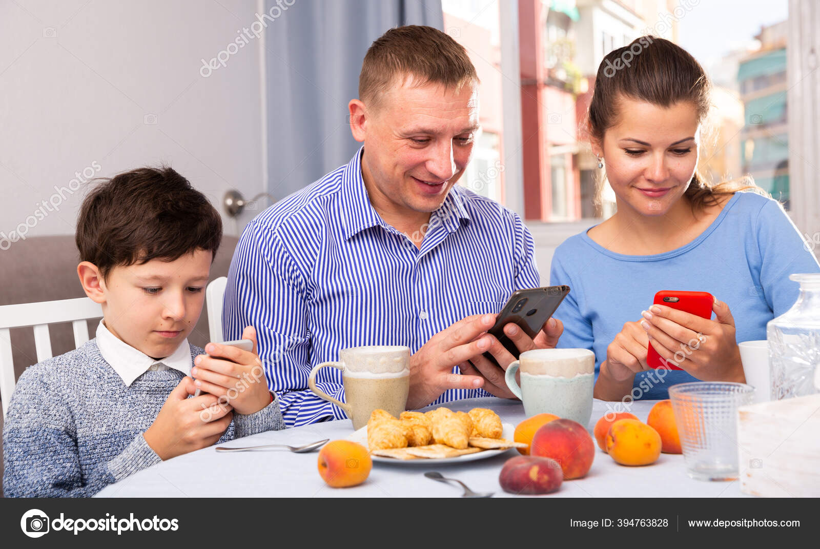 Boy and his parents using phones — Stock Photo © Jim_Filim #394763828