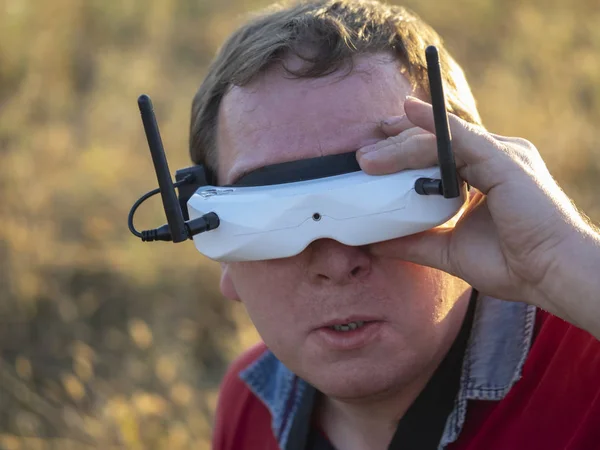 Drone pilot wearing first-person view headset. Young man driving a quad ...