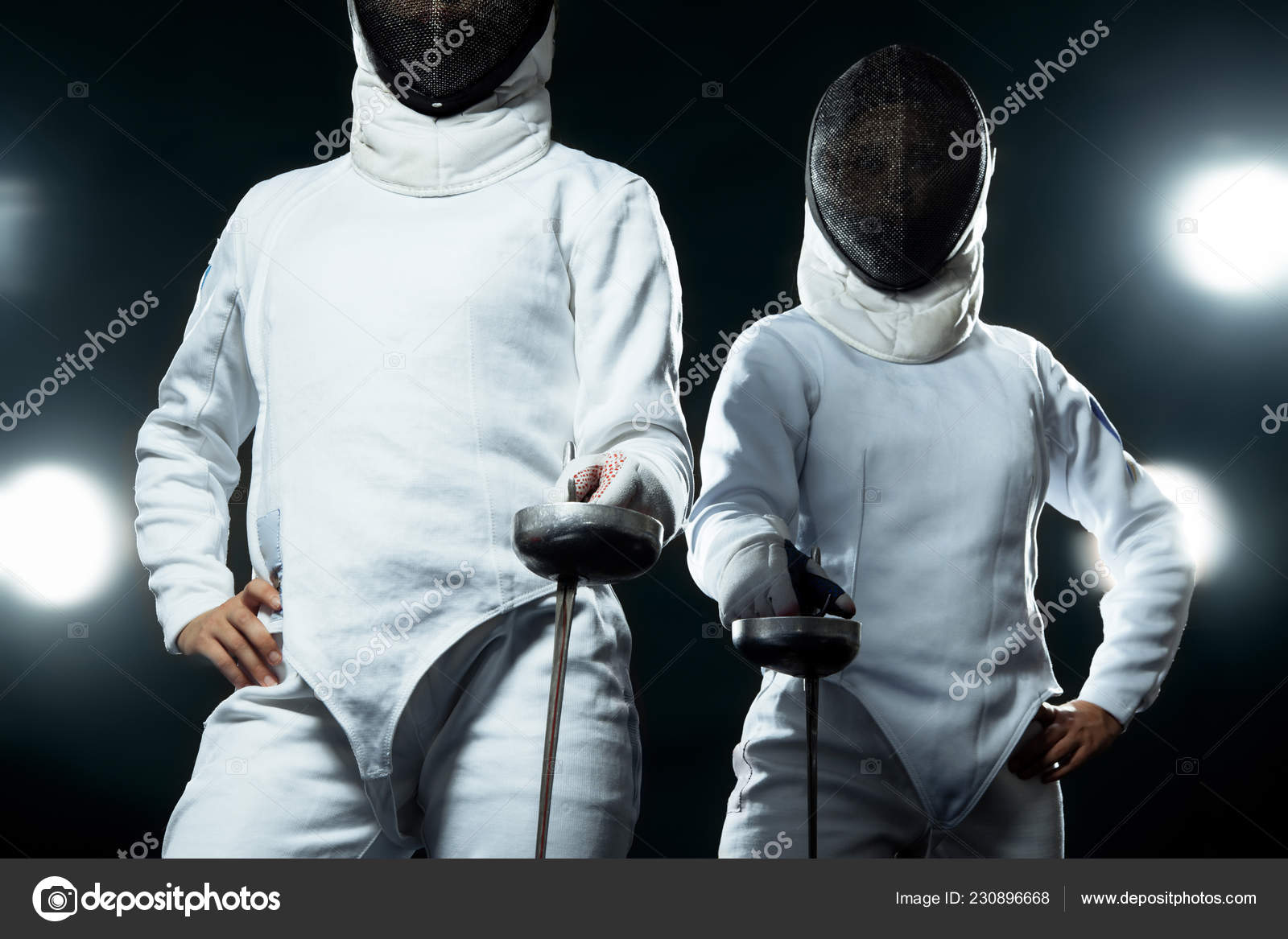 Young fencer athlete wearing mask and white fencing costume. holding the sword on black ...