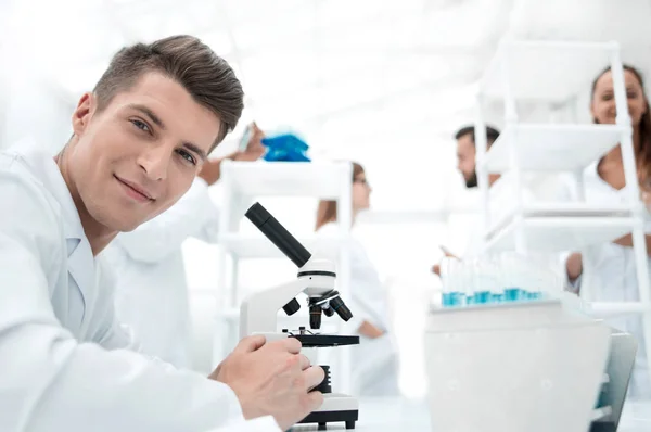 cheerful laboratory worker using microscope in lab - Stock Image ...
