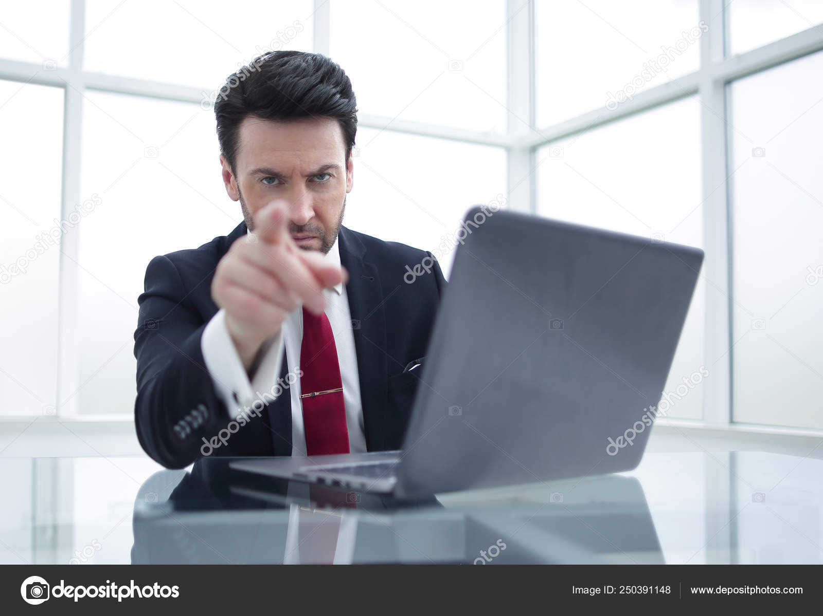 Serious Businessman pointing the finger at you,sitting at his Desk ...