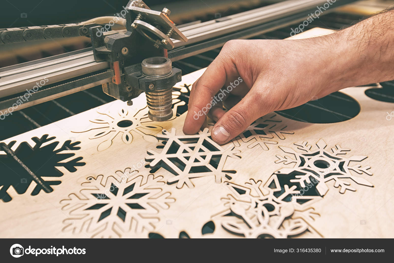 The man is working with laser cutter machine and takes the fini Stock ...