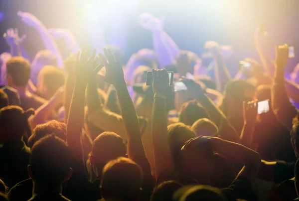 Concert stage lights and crowd on dance floor partying to the music ...