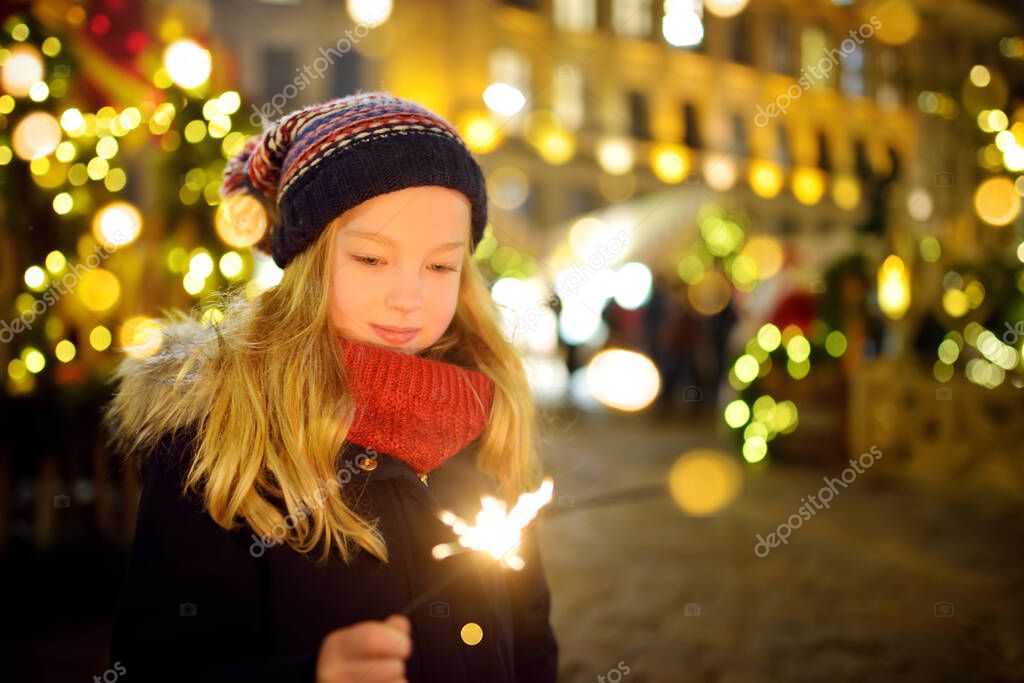 Linda joven sosteniendo chispas cerca de un árbol de Navidad en la ...