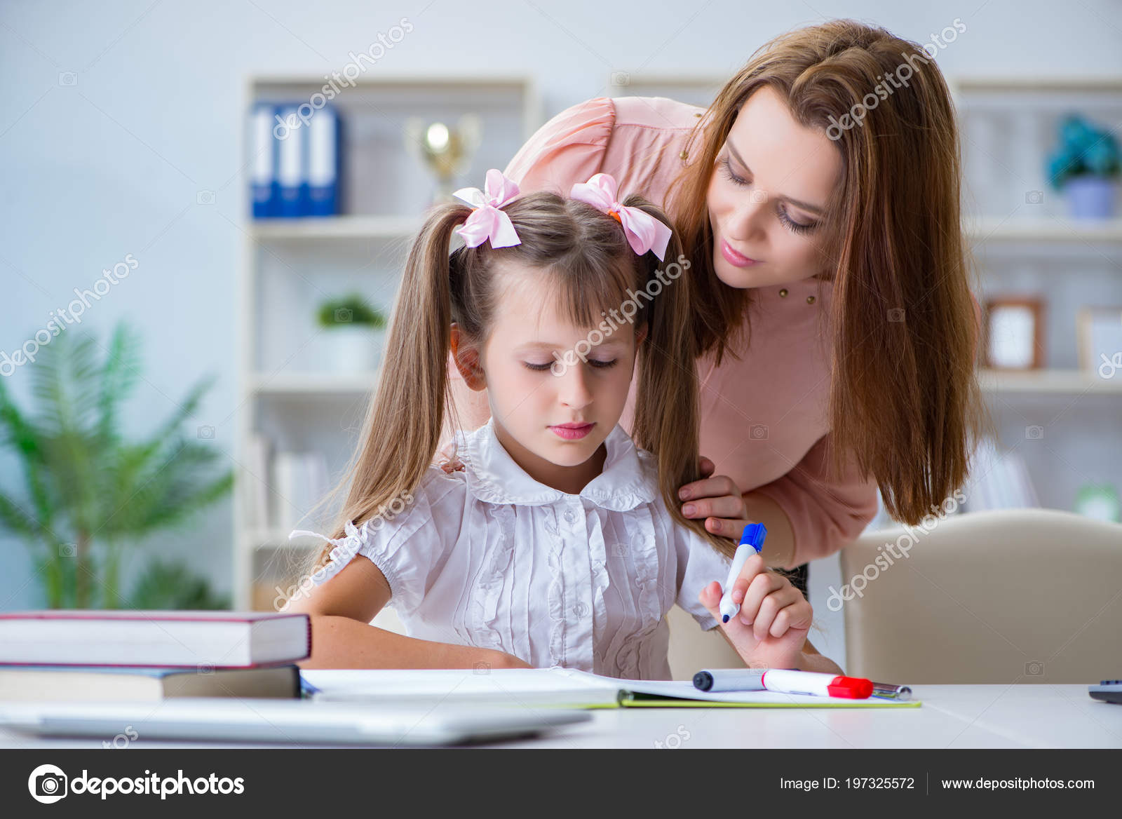 Mother helping her daughter to do homework Stock Photo by ©Elnur_ 197325572