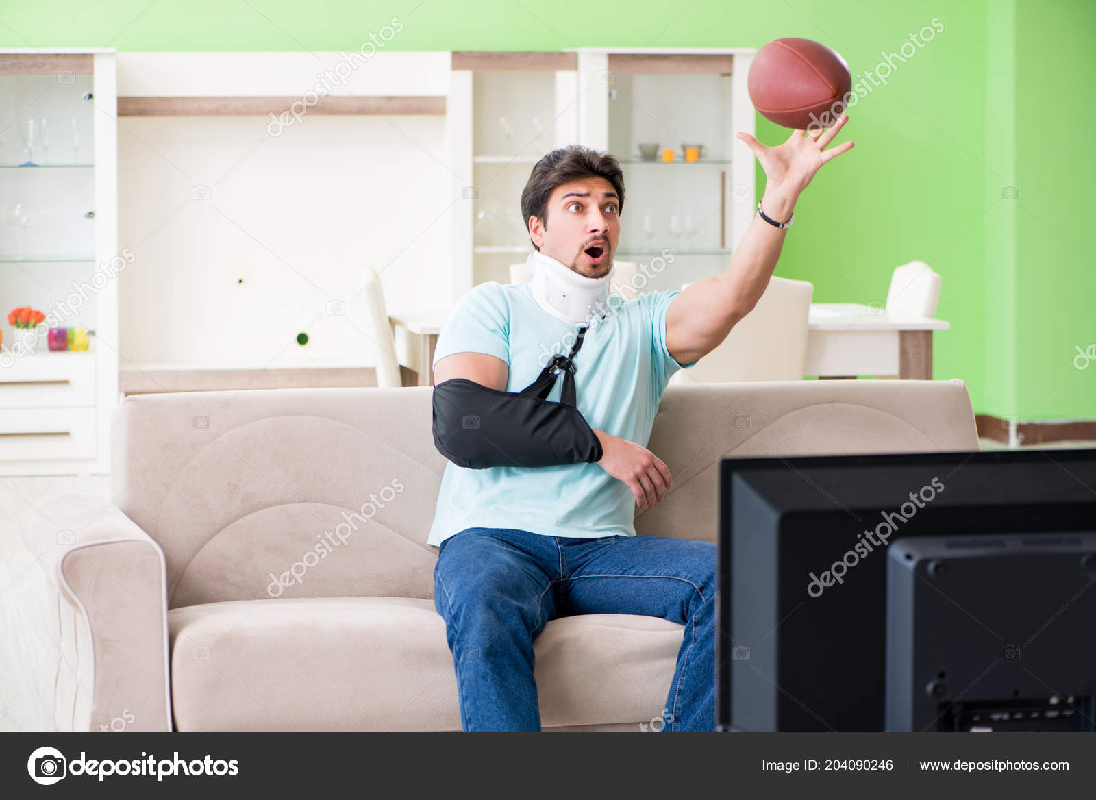 Man with neck and arm injury watching american football on tv Stock ...