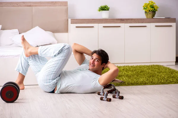 Young man doing morning routine in bedroom - Stock Image - Everypixel