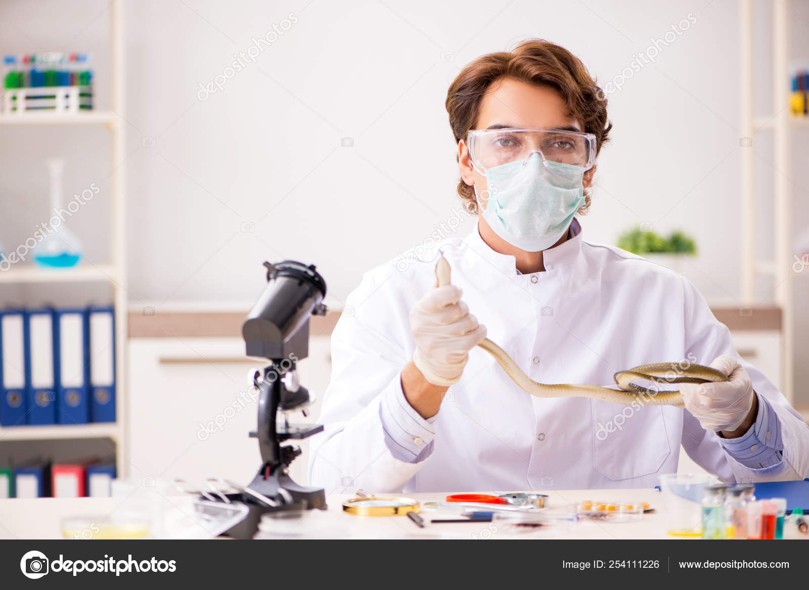 Male scientist extracting poison from snake for drug synthesis — Stock ...