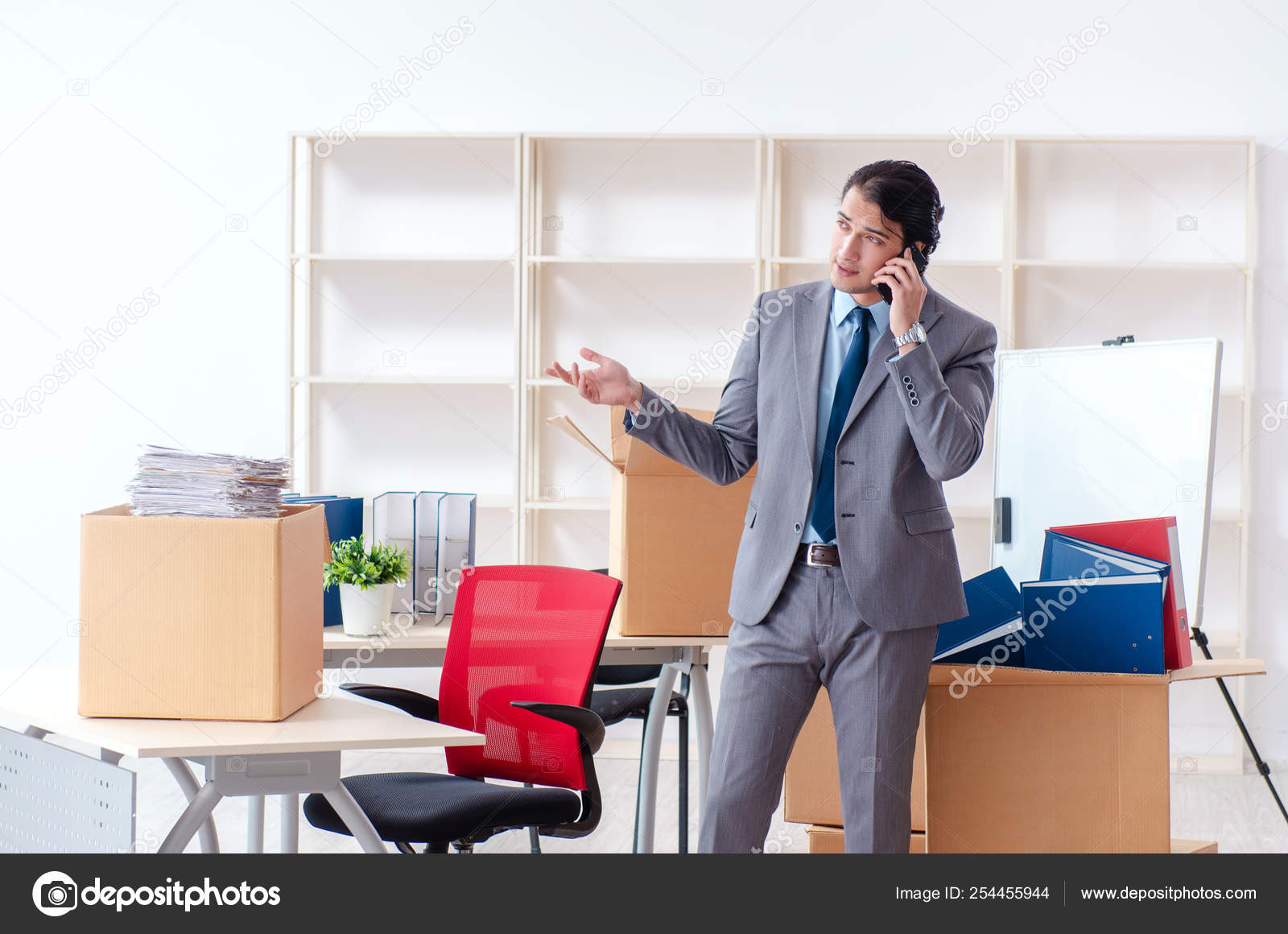 Young man employee with boxes in the office Stock Photo by ©Elnur ...