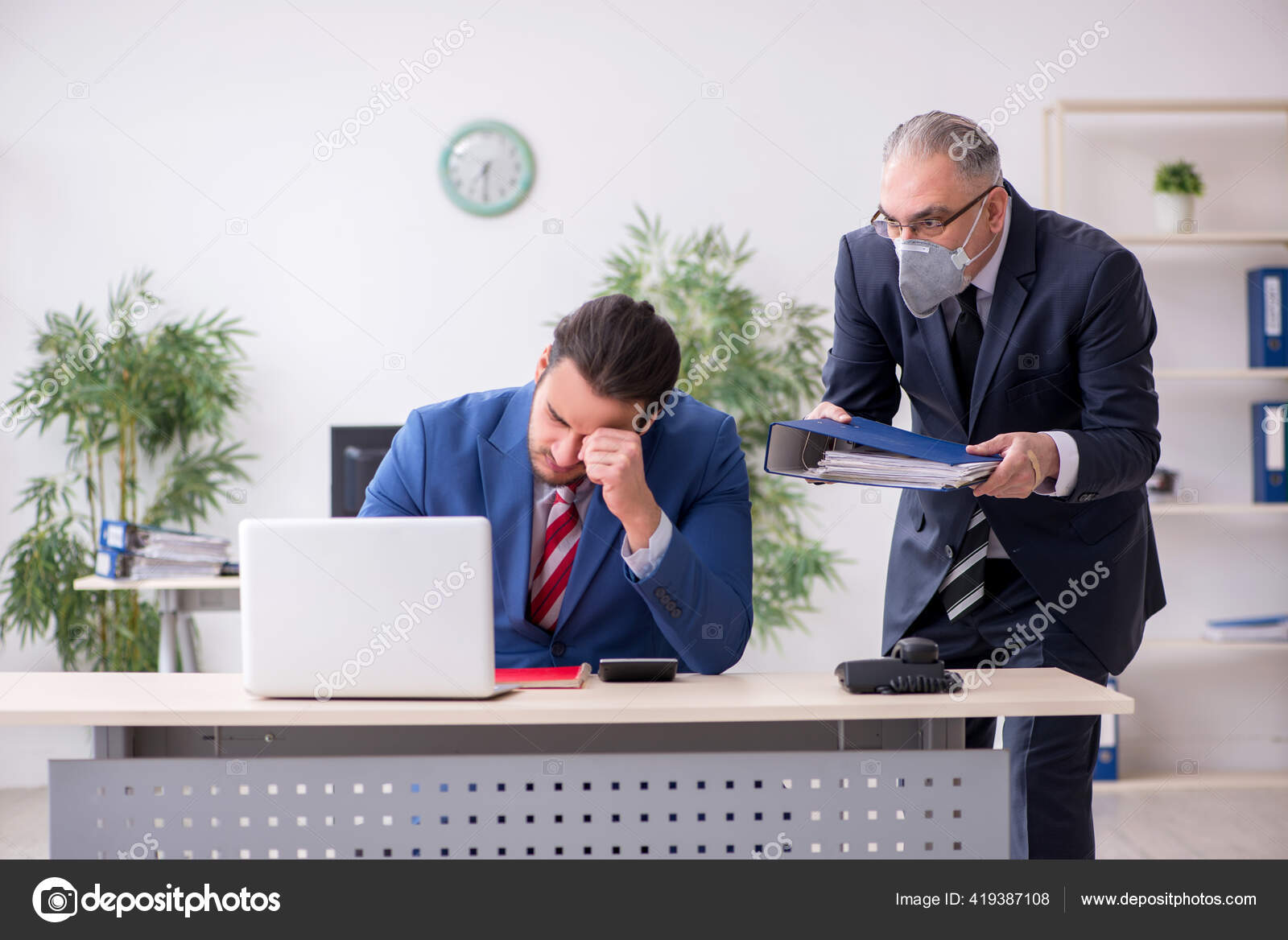 Two employees at workplace during pandemic Stock Photo by ©Elnur_ 419387108