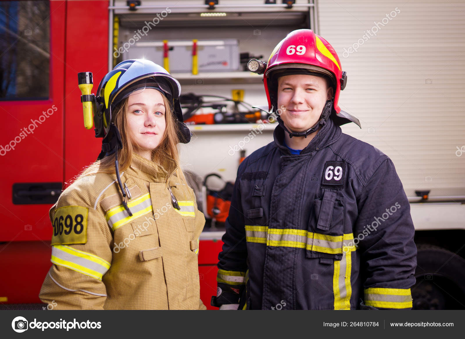 Photo of firefighters women and men in helmets looking at camera near ...