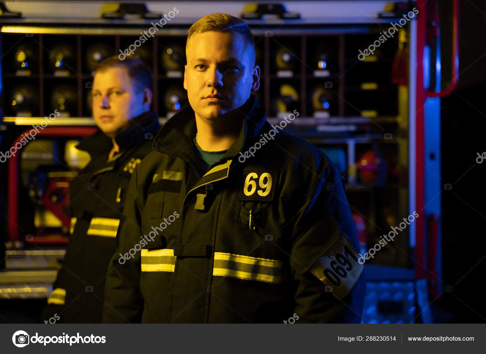 Image of two firefighter looking into camera near fire truck — Stock ...