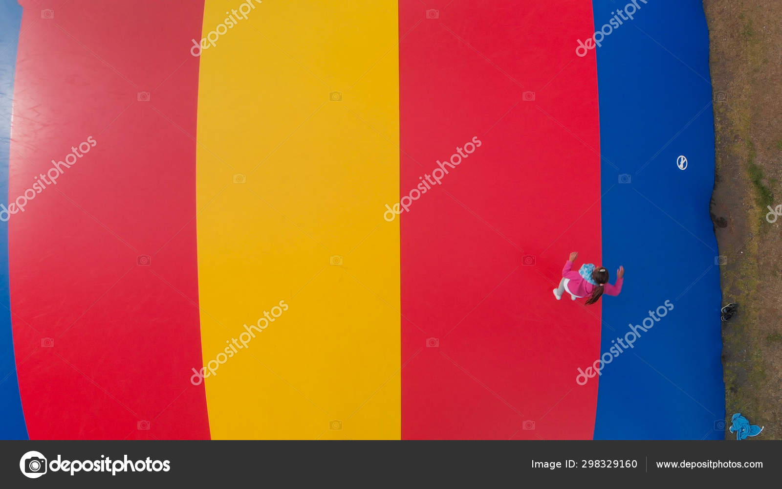 Child playing on the playground trampoline, aerial view from a h ...