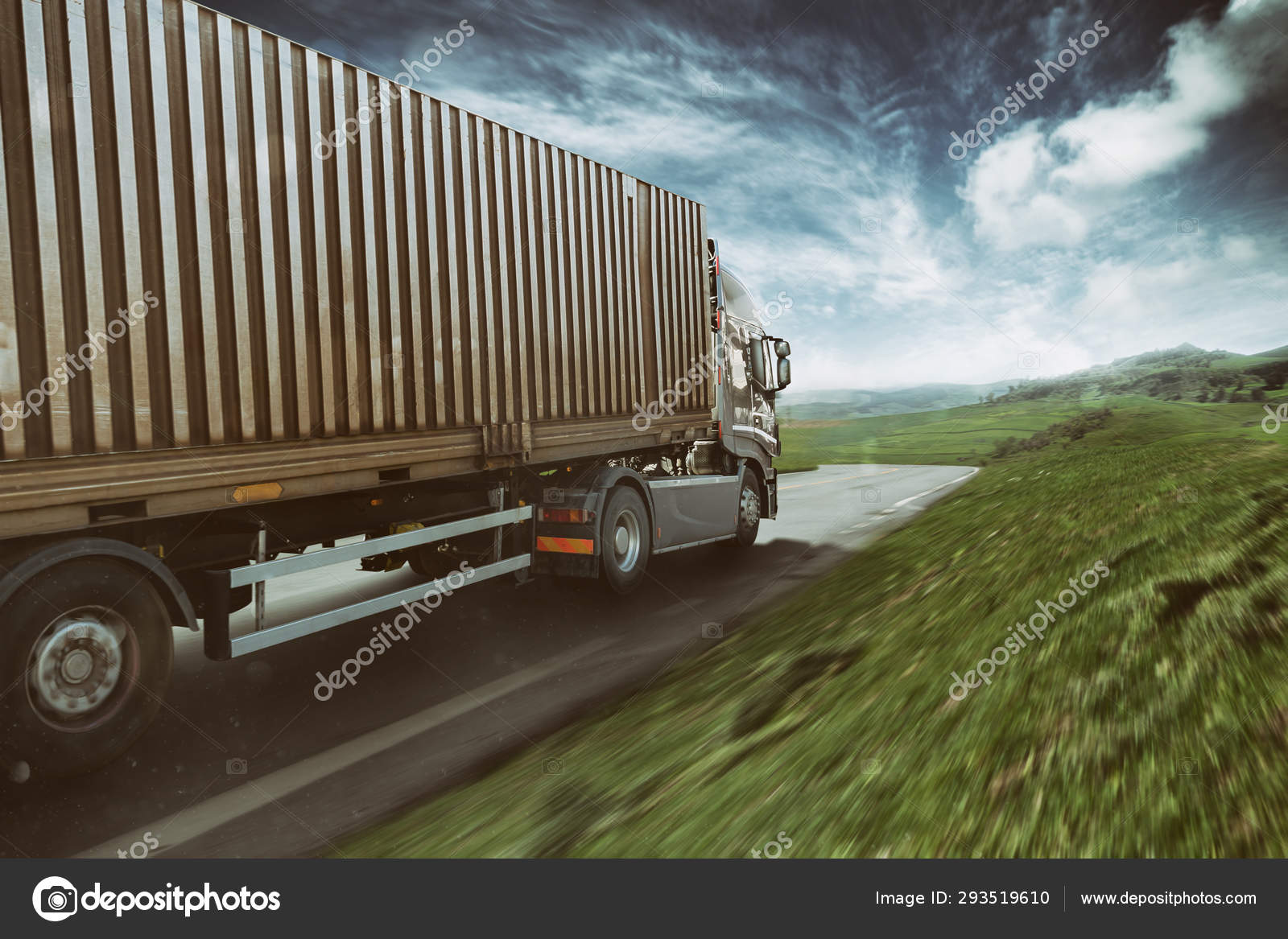 Grey truck moving fast on the road in a natural landscape with cloudy ...