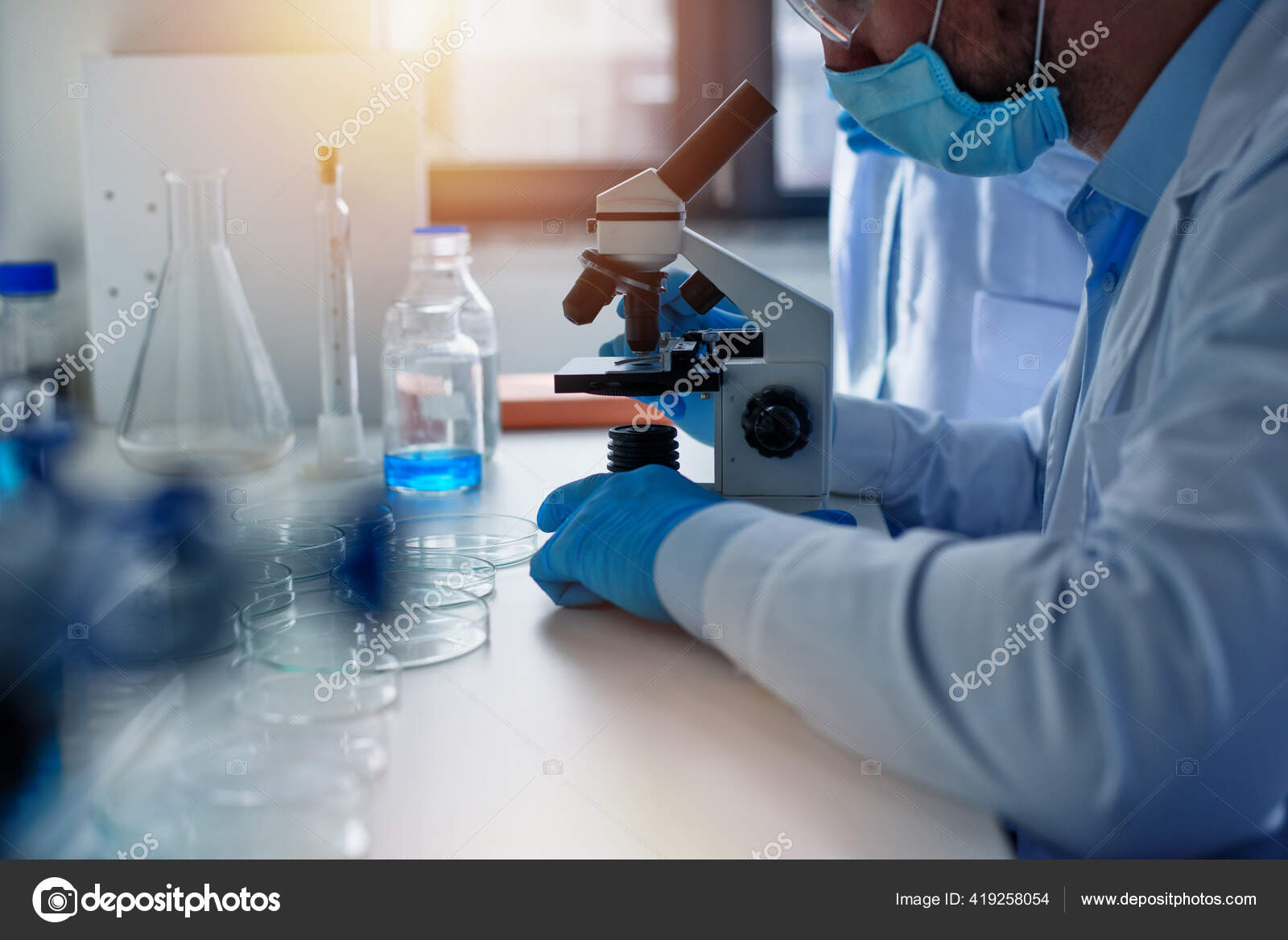 Doctor in the laboratory analyzes samples under a microscope ...