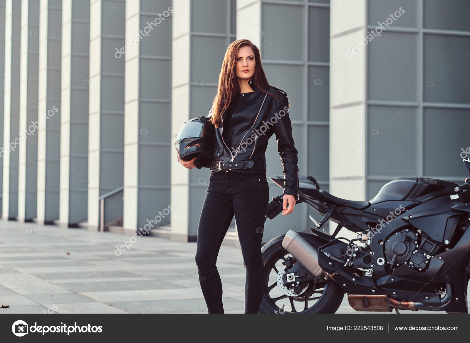 A Beautiful Biker Girl Holding Helmet Next Superbike Outside A Building