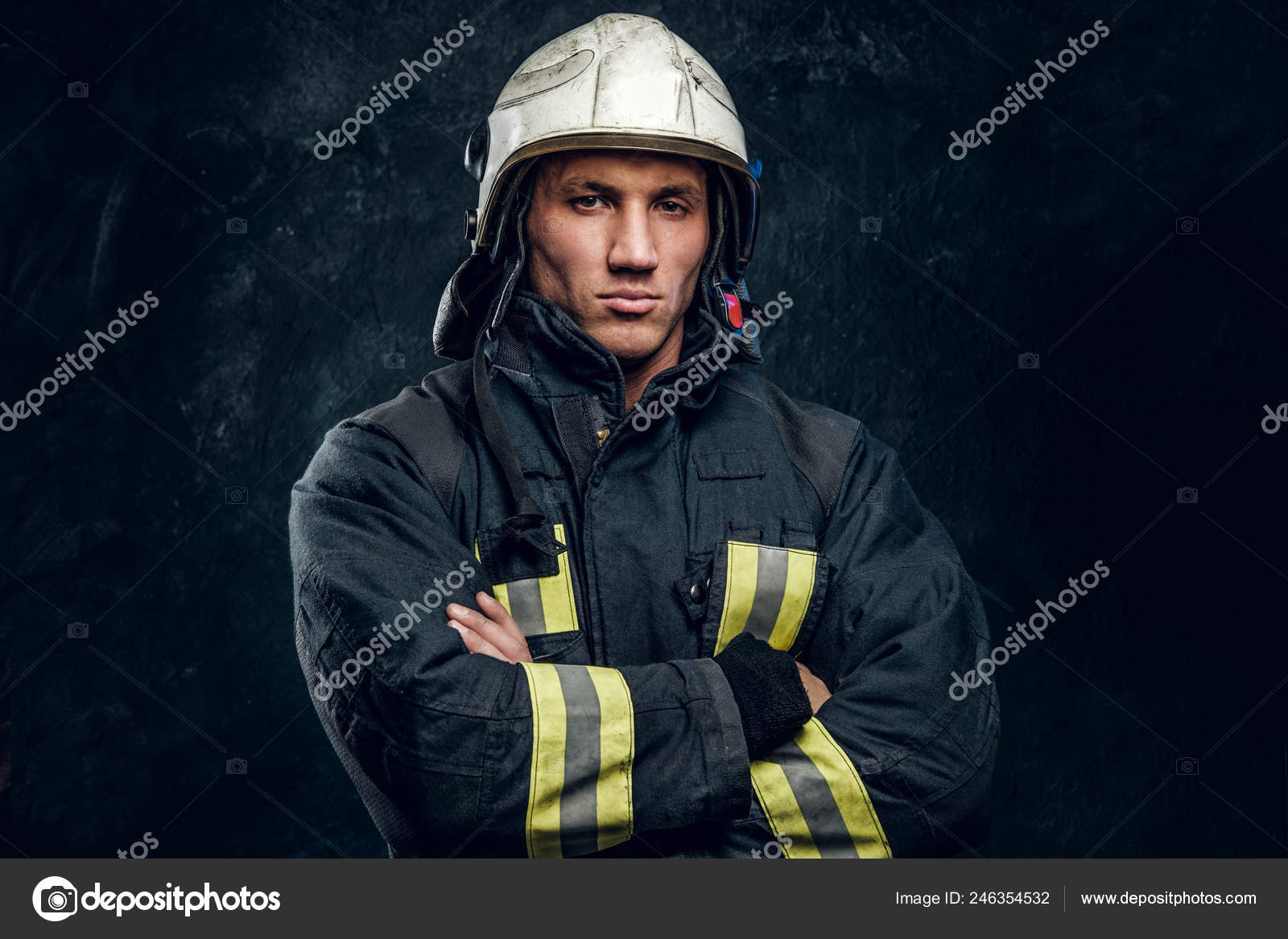 Brutal fireman in uniform posing for the camera standing with crossed ...