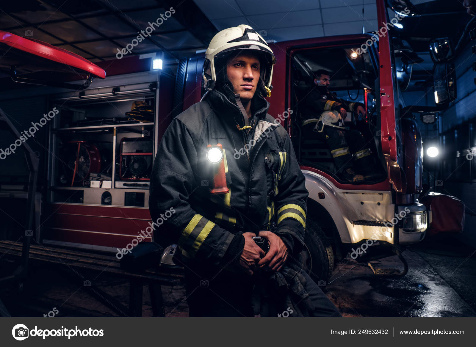 The fire brigade came to the call at night. Handsome fireman wearing a ...