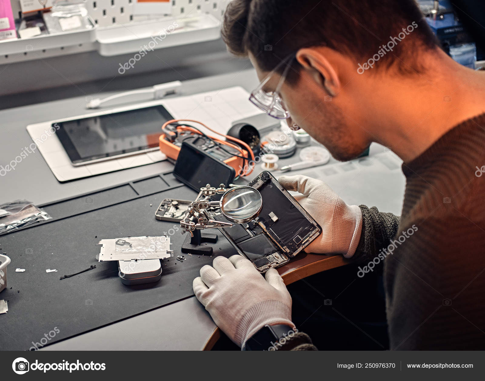 Technician uses a magnifying glass to carefully inspect the internal ...