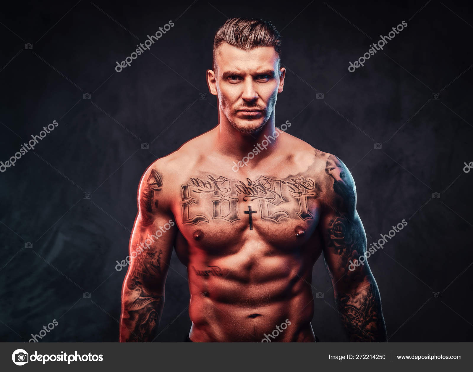 A muscular tattooed man on a dark background. — Stock Photo © fxquadro ...