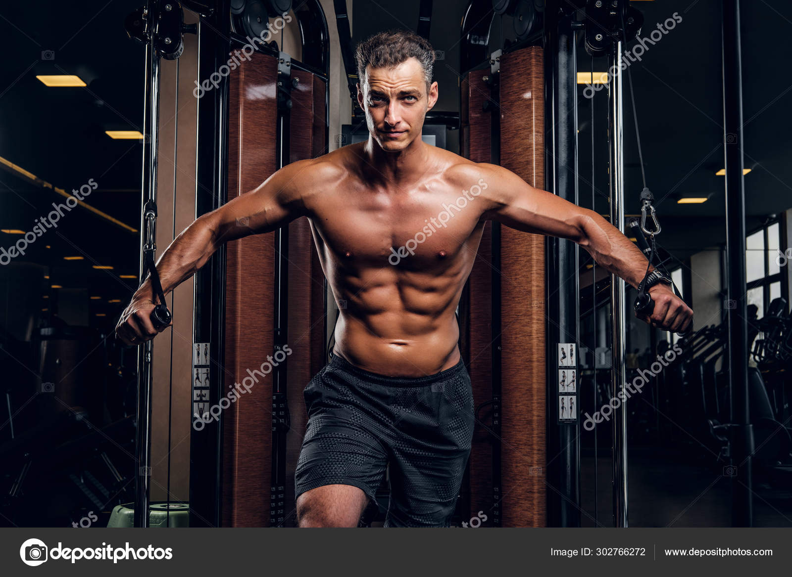 Muscular man is doing exercises with training apparatus Stock Photo by ...