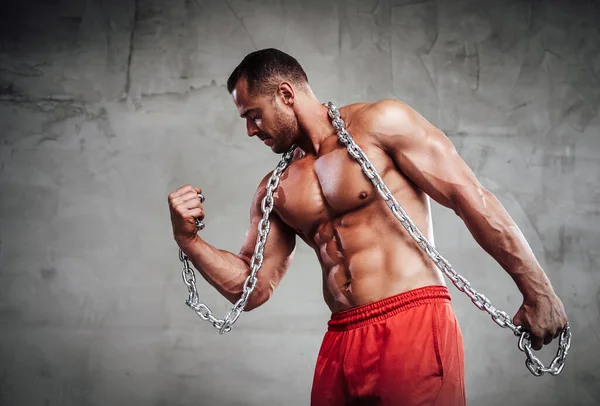 Shirtless guy with huge biceps and strong arms holding chains — Stock ...