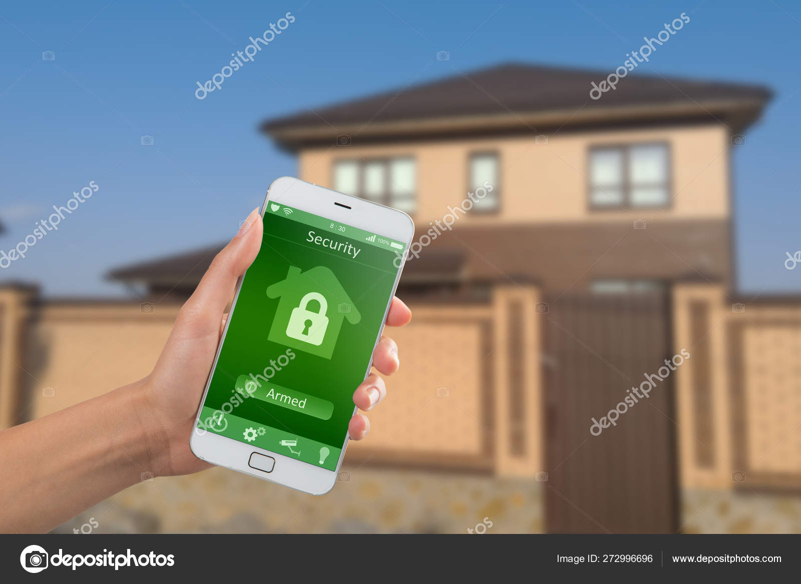 Smartphone with home security app in a hand on the building background ...