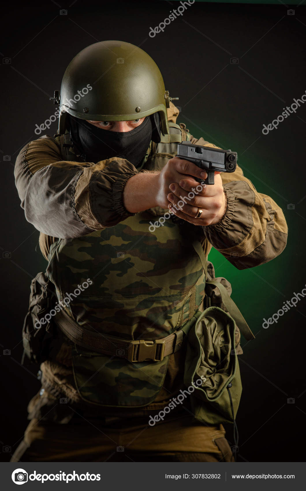A man in uniform with a gun posing, aiming, reloading, shooting, on a ...