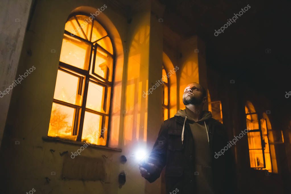 Hombre con linterna en oscuro espeluznante mansión abandonada por la ...