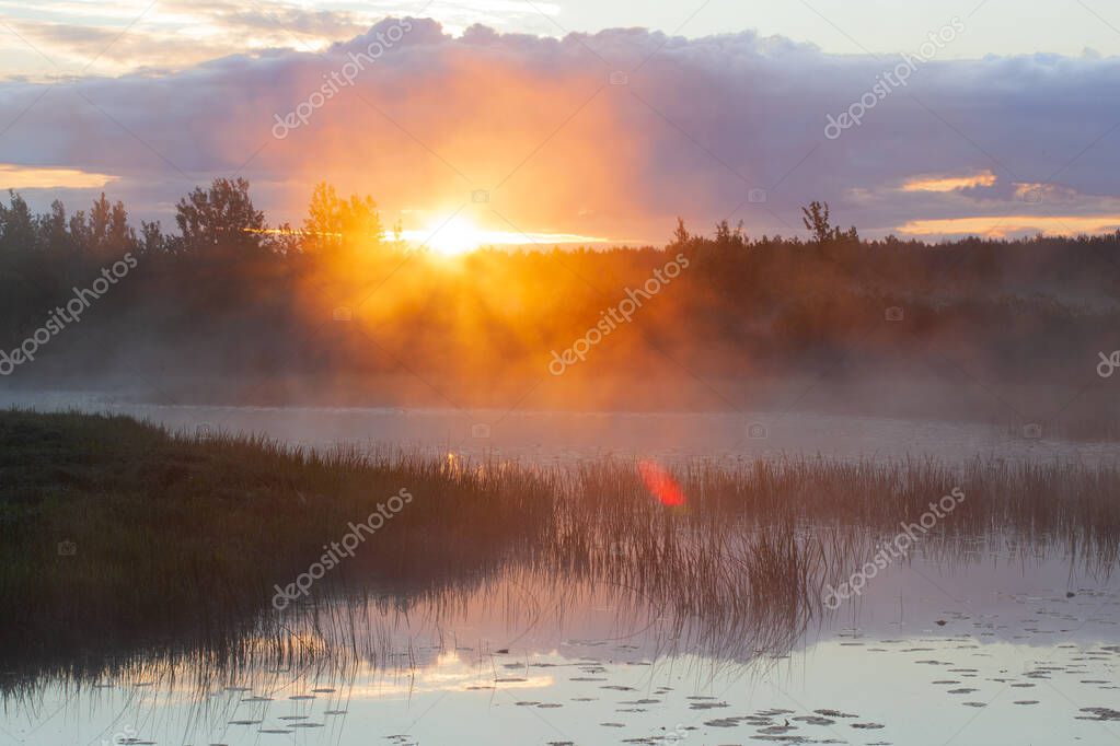 Luz naranja soleada con rayos y sombras sobre el río brumoso al ...
