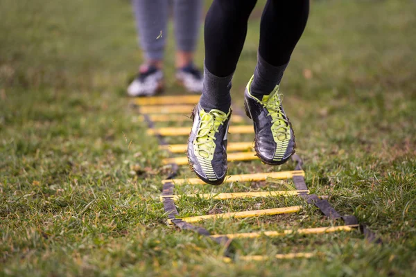 closeup of young american football player exercises on ladder drills at ...