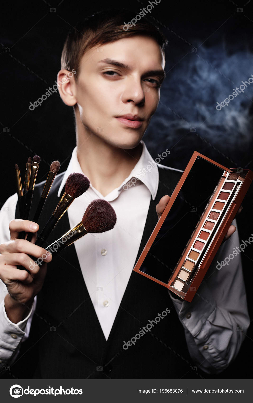 Beauty concept. Young male make up artist posing with make-up brushes ...