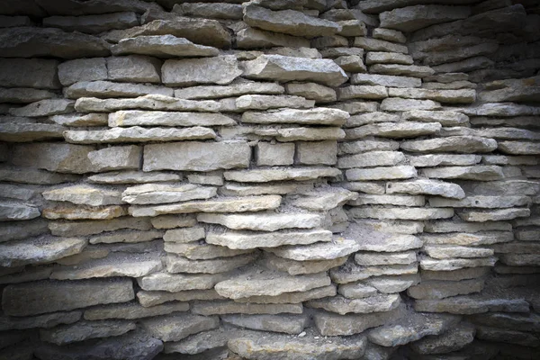 Ancient crumbling fortress wall of white flat protruding limestones ...