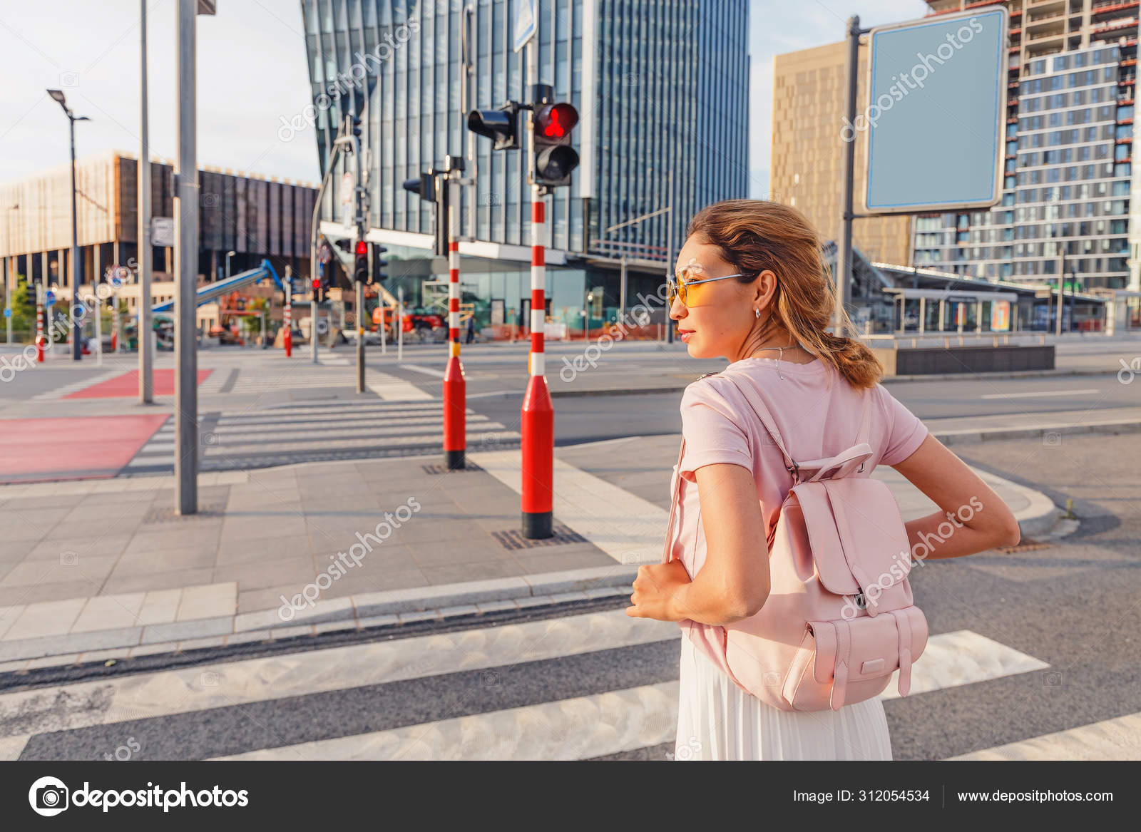 The girl is going to cross the road on a prohibiting red light. Road ...