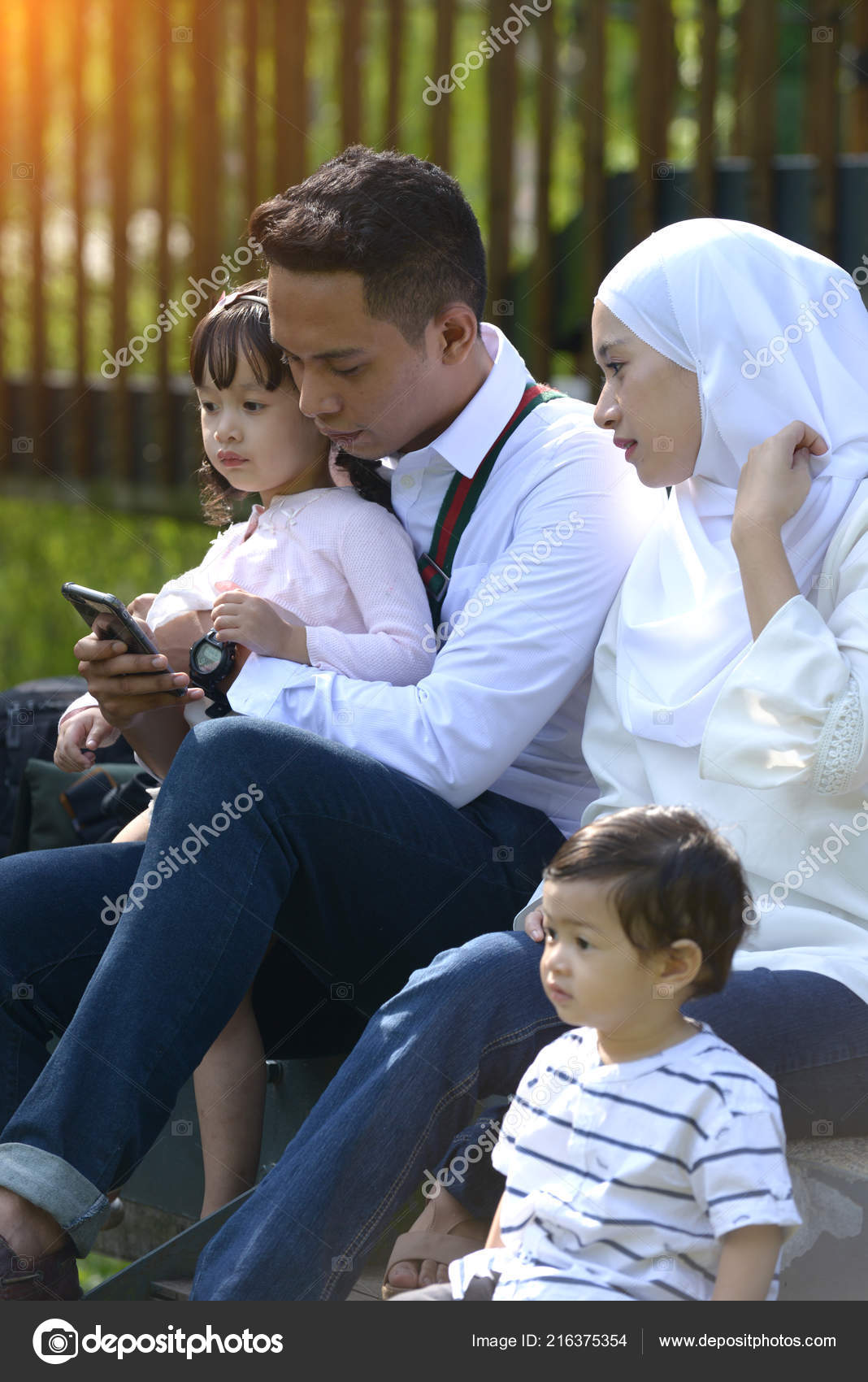 Malay Father Using Smartphone Outdoor — Stock Photo © yuliang11 #216375354