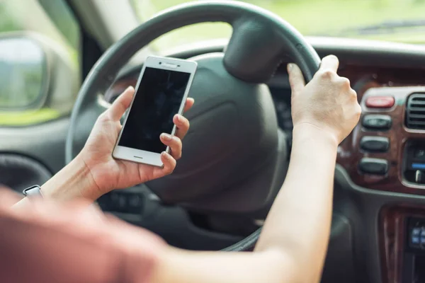 women driver with a cell phone in hand while driving - Stock Image ...