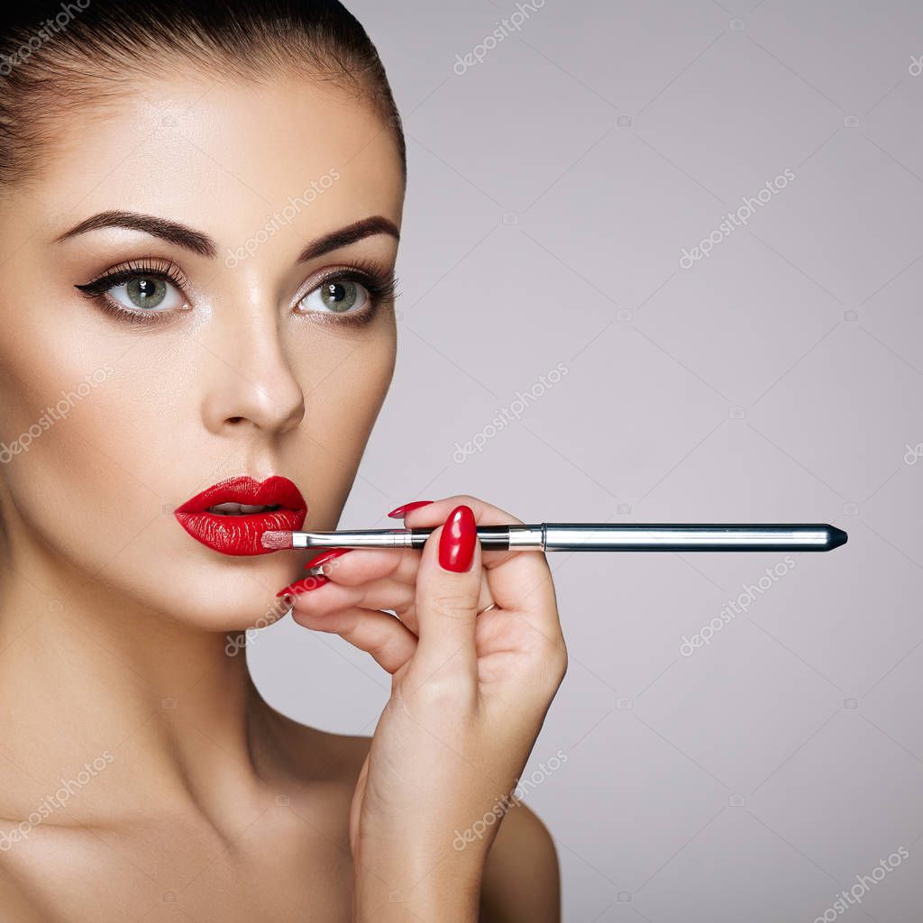 Hermosa mujer pinta labios con lápiz labial. Hermosa cara de mujer ...