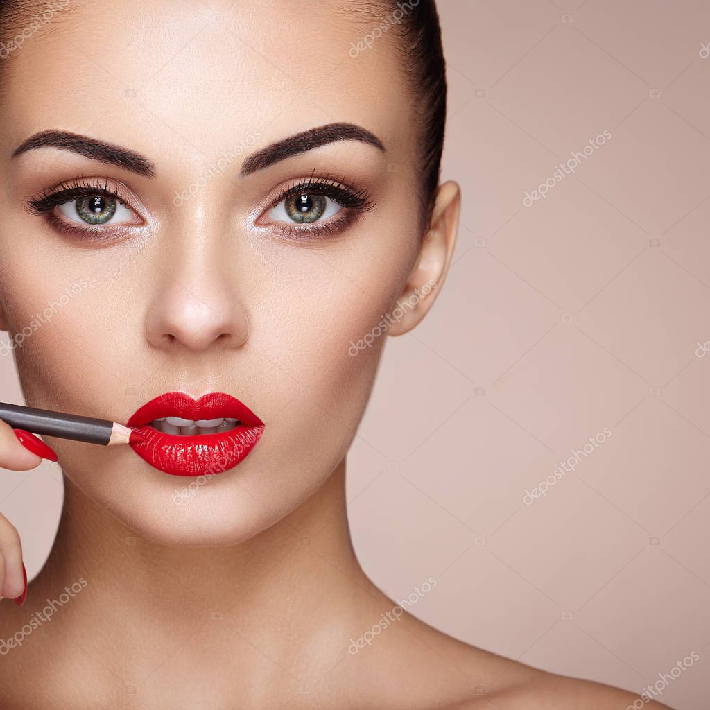 Hermosa mujer pinta labios con lápiz labial. Hermosa cara de mujer ...