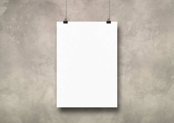 White poster hanging on a light concrete wall with clips. Blank mockup ...