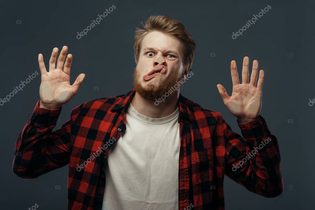 Cara loca del joven y las manos aplastadas en vidrio transparente ...