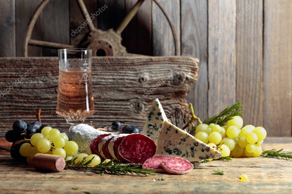 Bodegón rústico con vino y aperitivos. En un viejo vino de mesa de ...