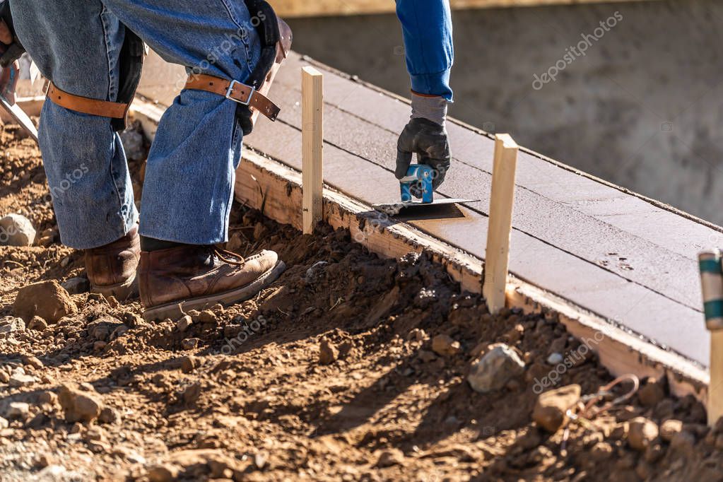 Trabajador de la construcción usando la mano Groover en el cemento ...