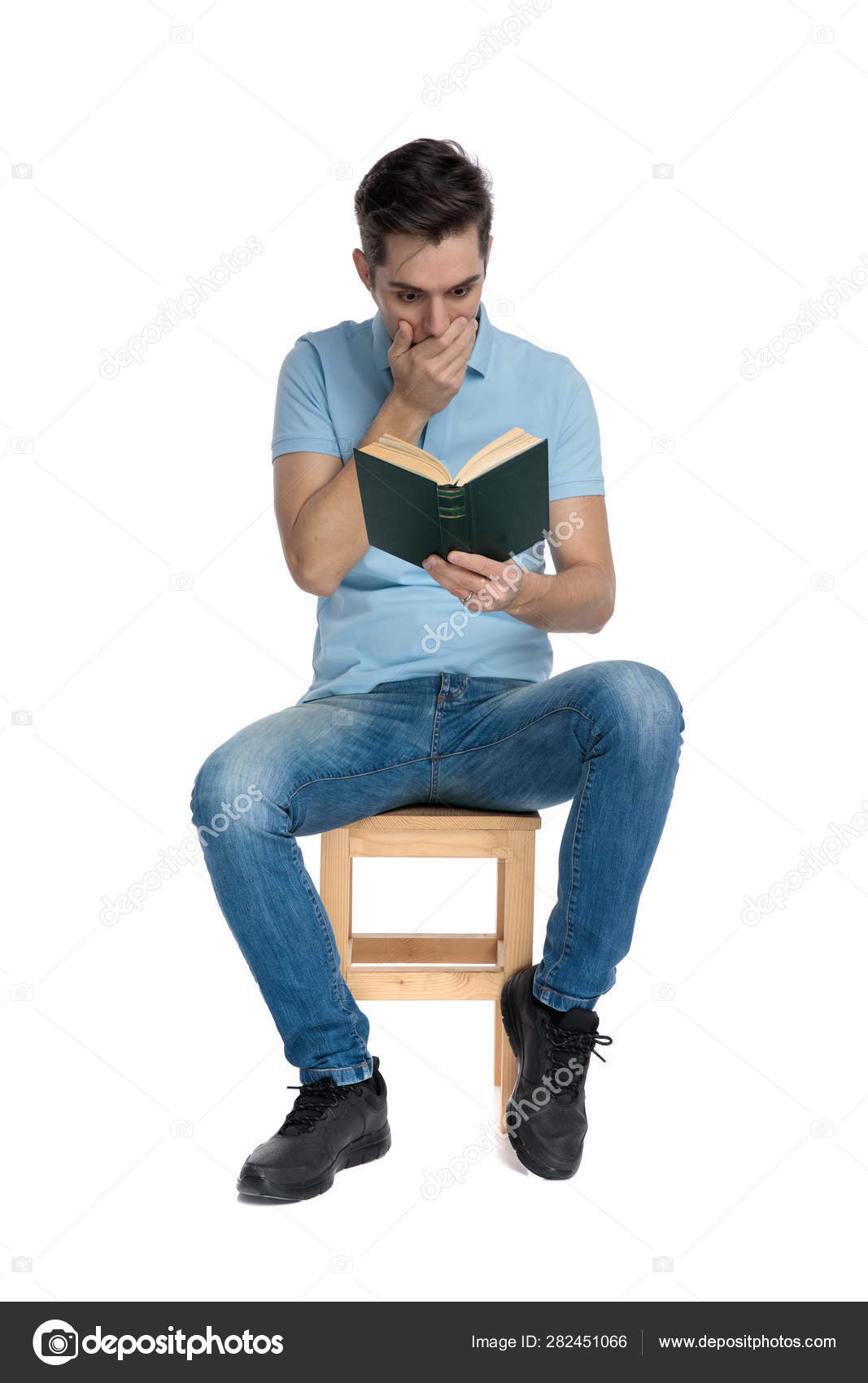 Shocked casual guy reading a book and covering his mouth — Stock Photo ...