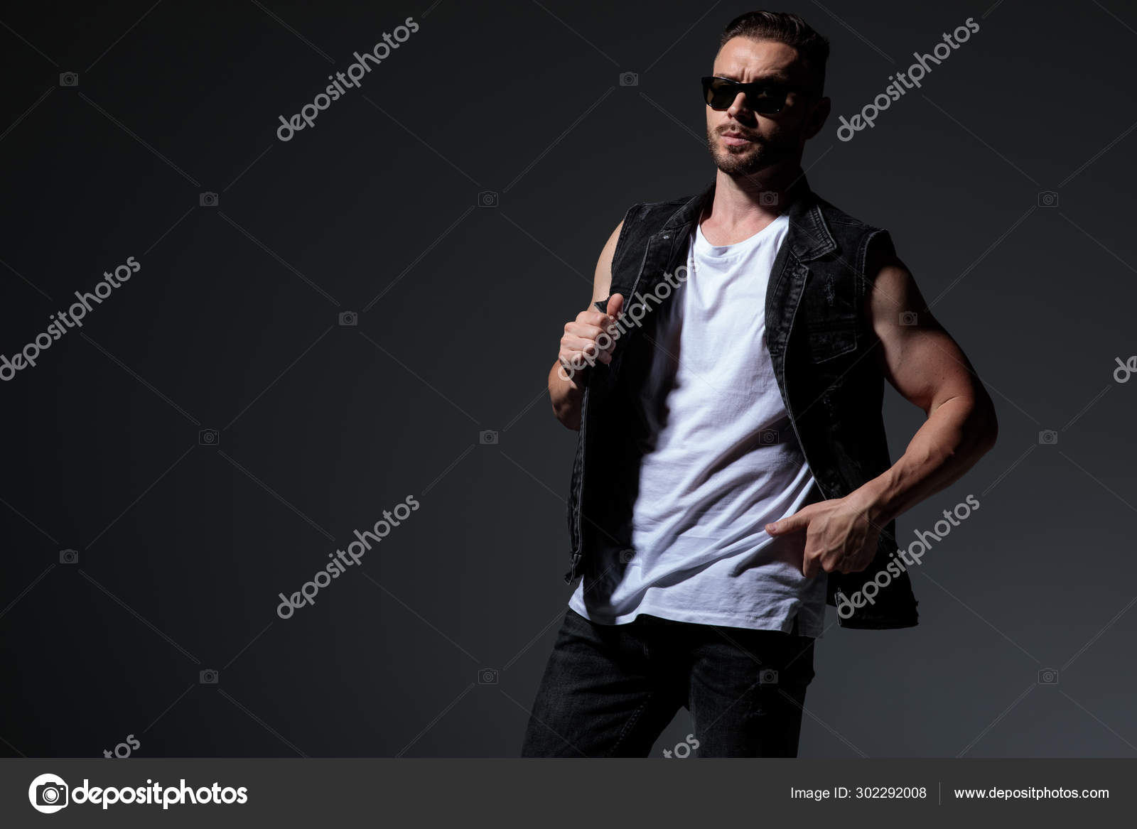 Sexy muscular man in black jeans holding jacket's collar Stock Photo by ...