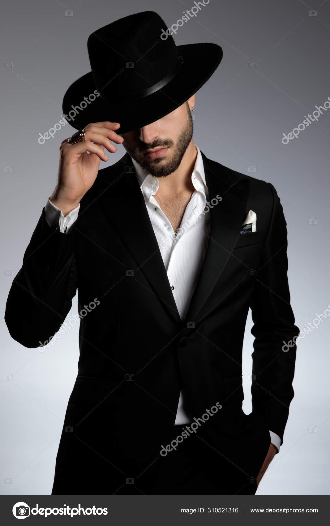Mysterious young man pulling hat down and saluting Stock Photo by ...