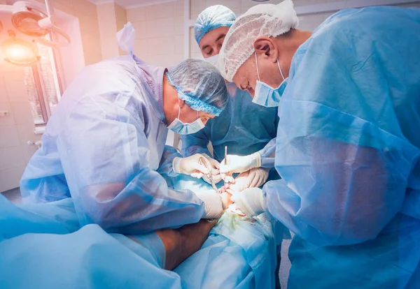 Process of trauma surgery operation. Group of surgeons in operating ...